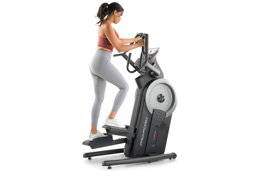 Woman in coral sports bra and gray leggings using black ProForm ...